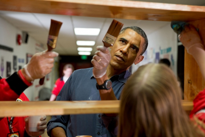 President Barack Obama stains shelves during a National Day of Service ...